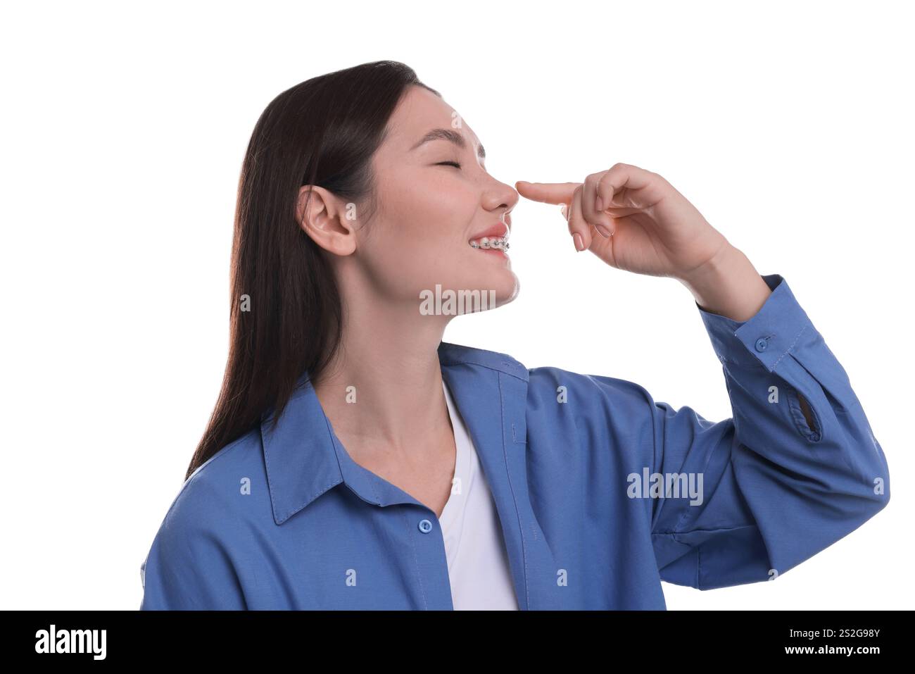 Young woman touching her nose on white background Stock Photo - Alamy