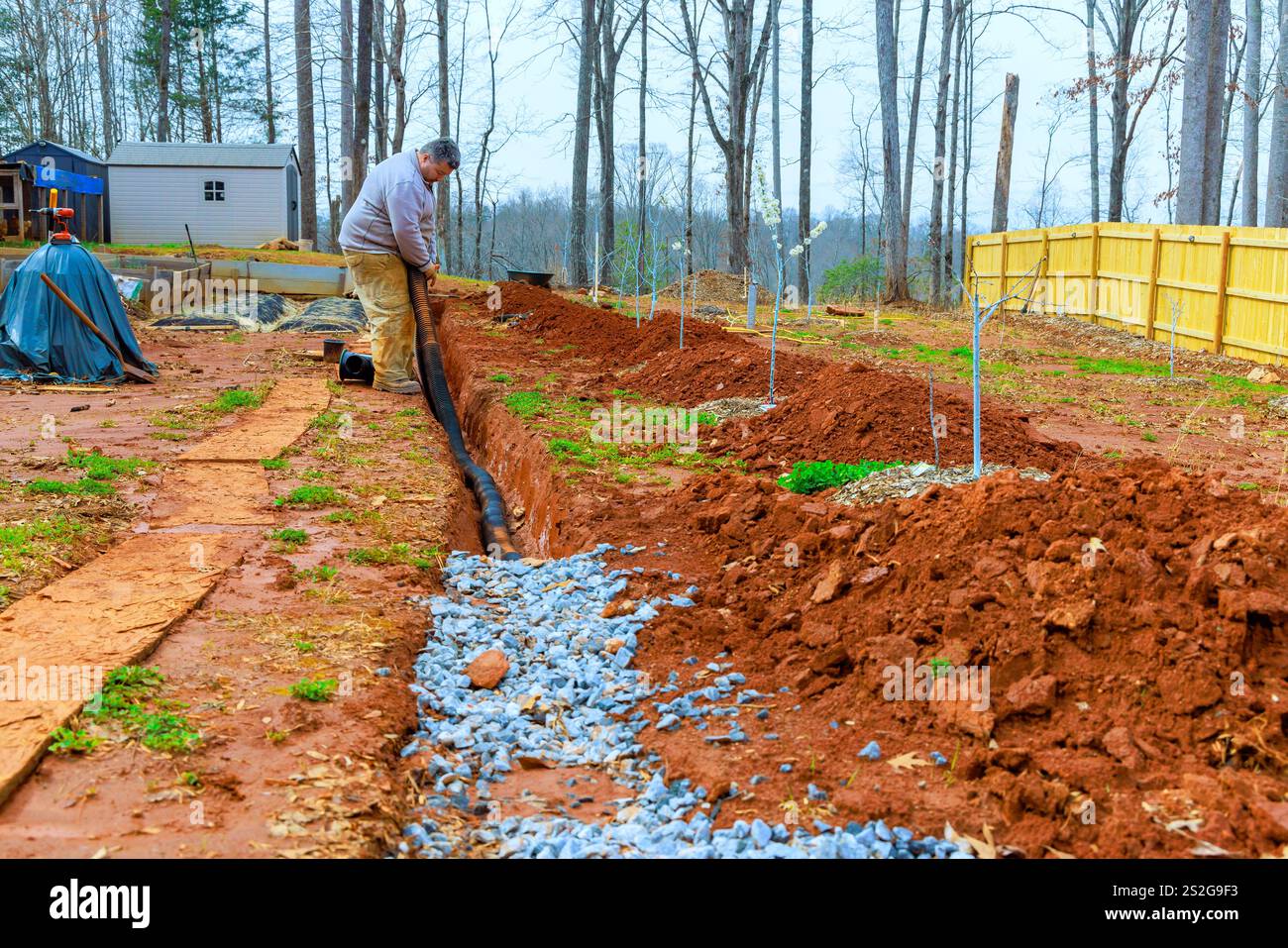 Contractor is digging trench for enhance water flow management, during ...