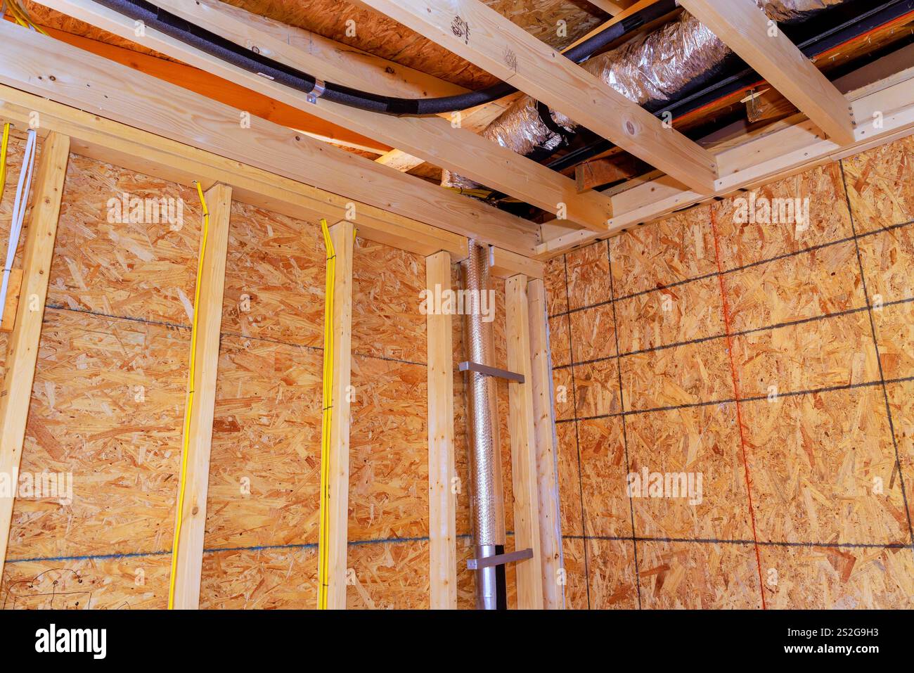 Construction work is underway with wooden framing, insulation visible in residential room under ...