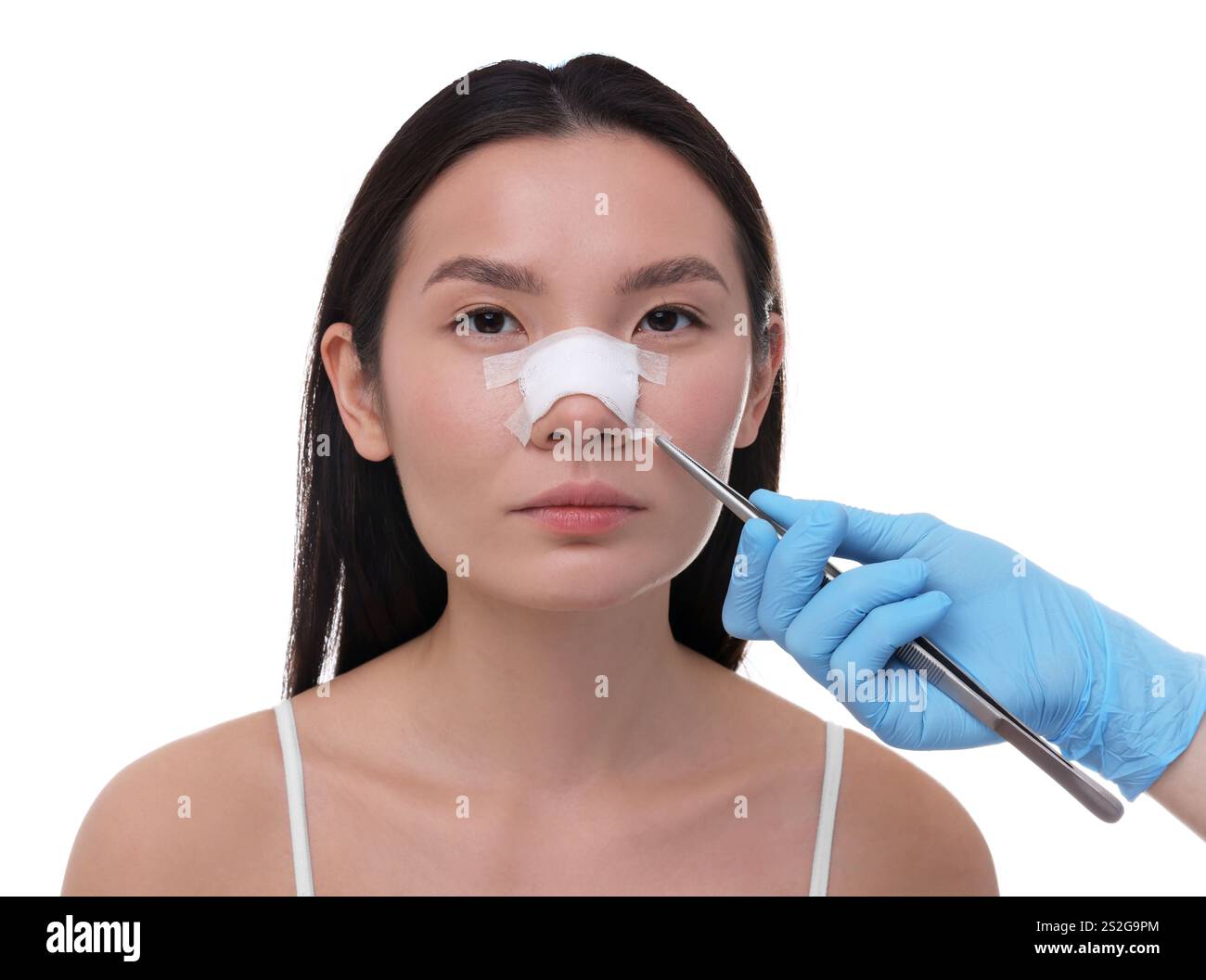 Doctor removing medical bandage from patient's nose after plastic ...