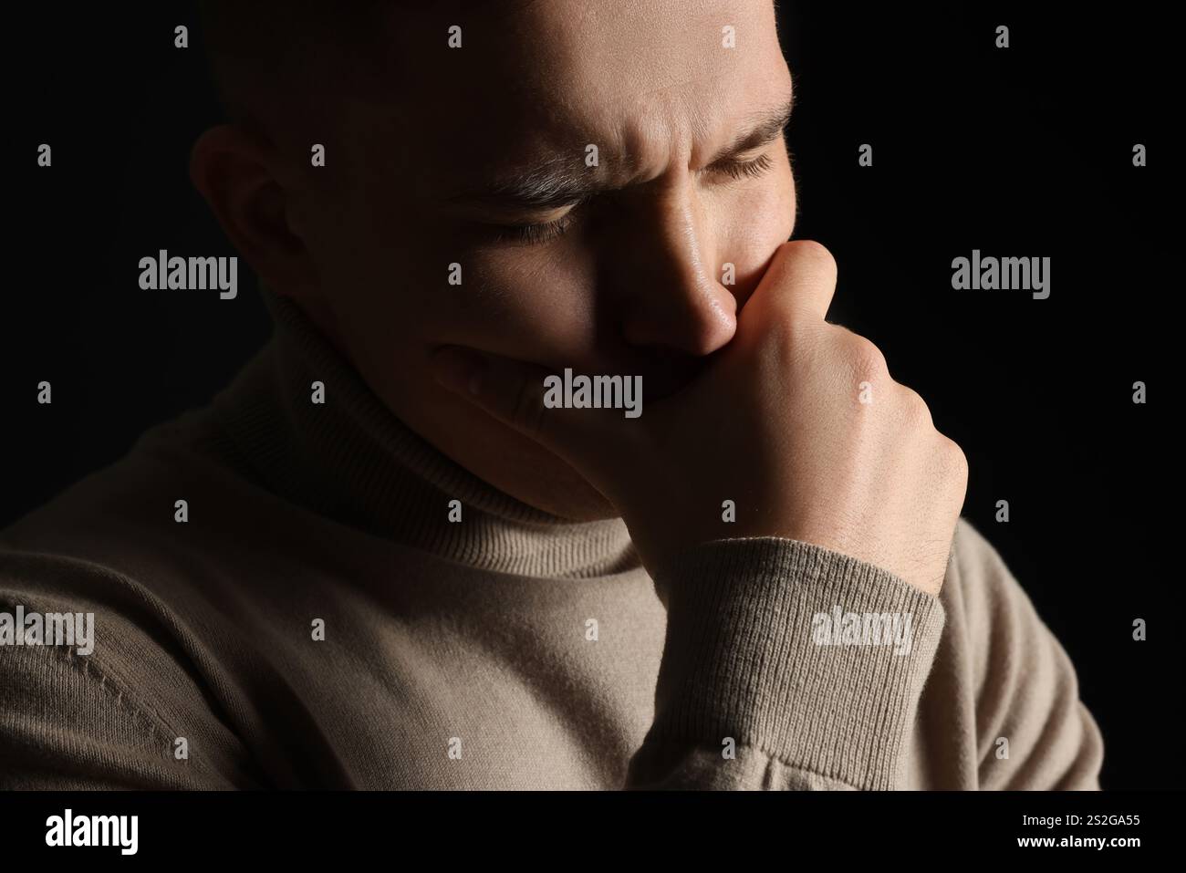 Distressed young man crying on black background, closeup Stock Photo ...