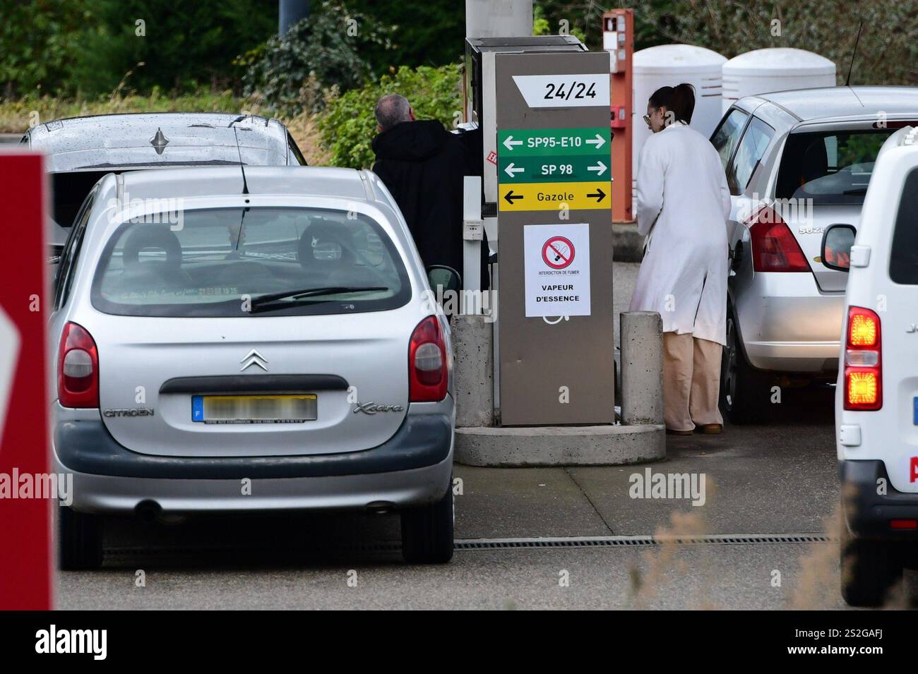 People are seen at a gas station of the Intermarche store in Saint ...