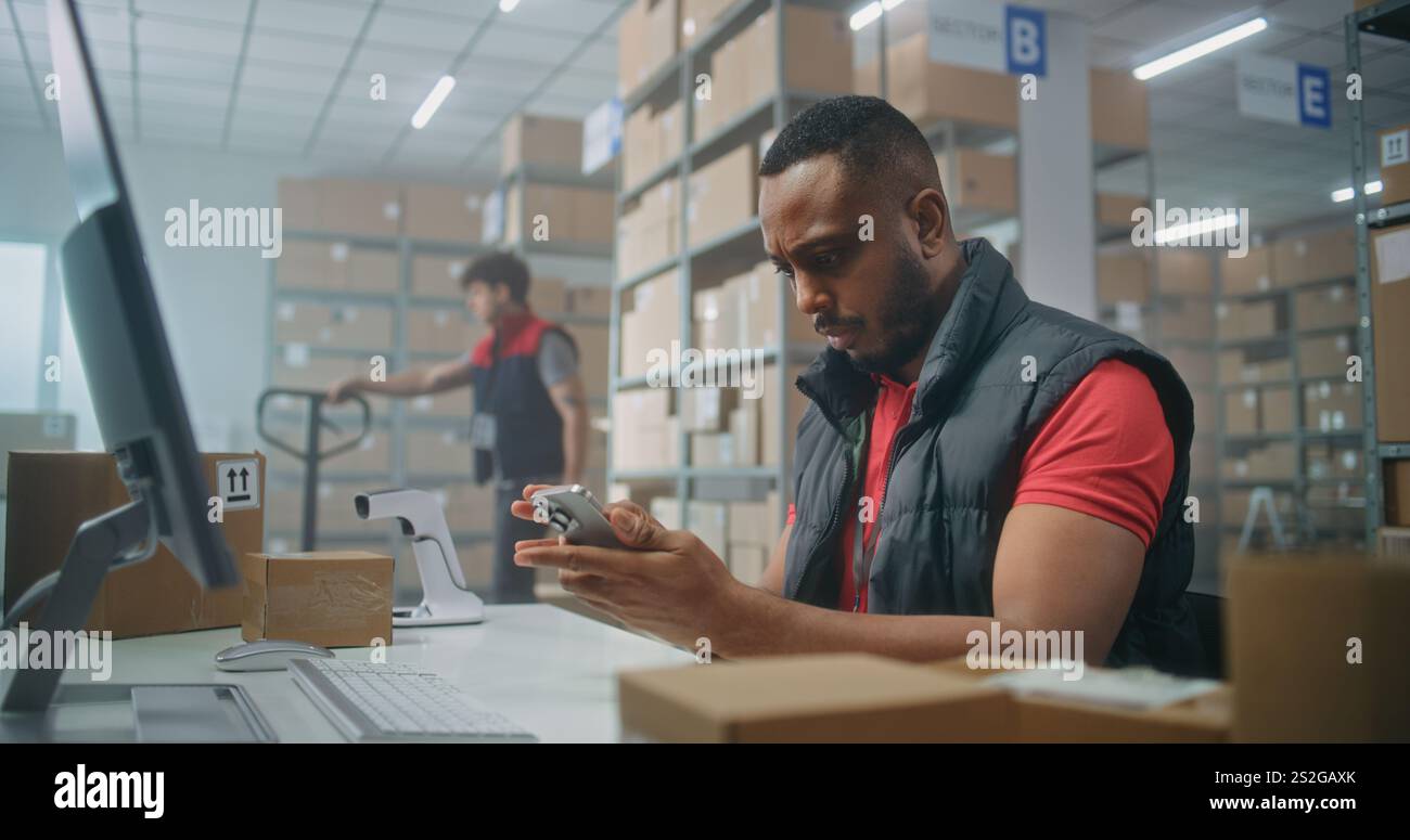 African American logistics manager scans parcels using smartphone ...