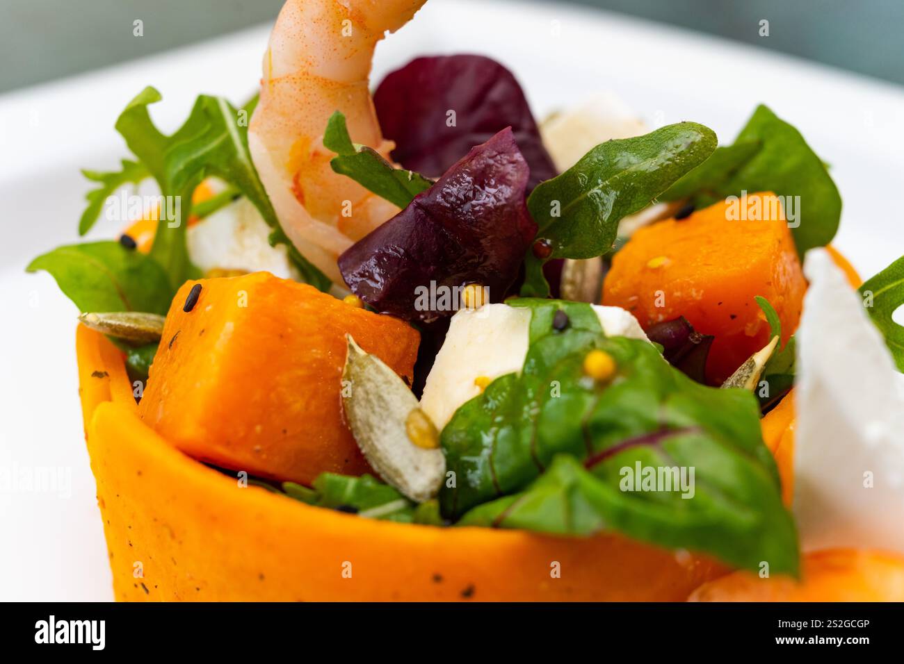 A colorful salad featuring fresh shrimp, diced vegetables like ...
