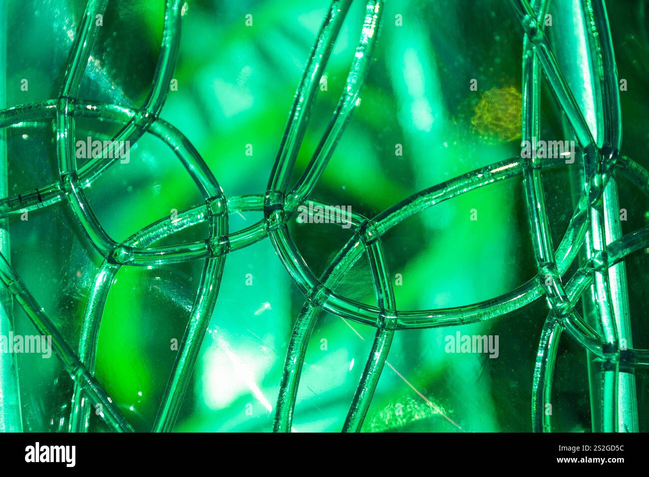 An intricate close-up of translucent green glass with intersecting ...