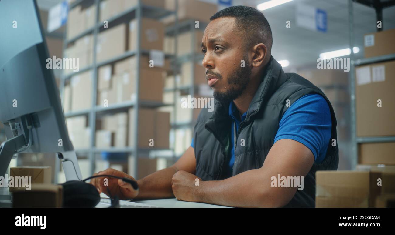 African American post office employee scans cardboard parcel using barcode scanner, works on ...