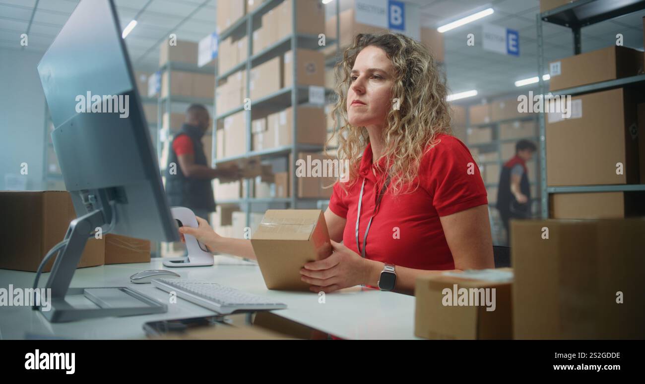 Female logistics specialist scans parcel using barcode scanner, checks data using computer ...