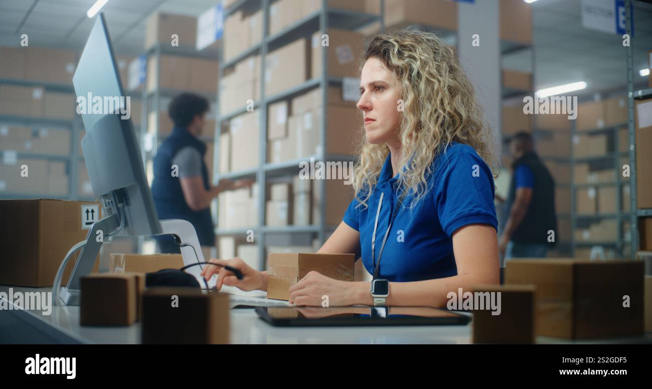 Female logistics specialist scans parcel using barcode scanner, checks data using computer ...