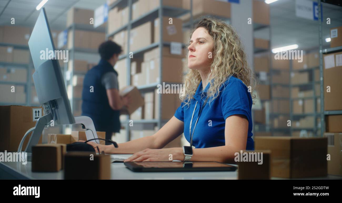 Female logistics specialist scans parcel using barcode scanner, checks data using computer ...