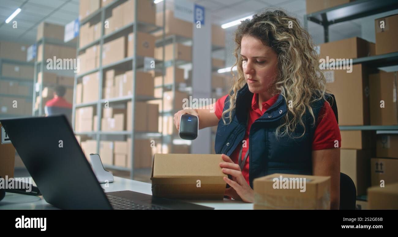 Female manager scans parcel using barcode scanner, enters data on laptop. Sorting center workers ...