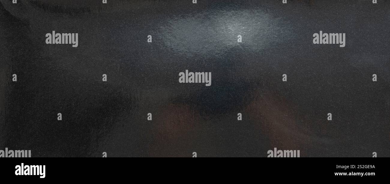 Dark, smooth surface reflects light and subtle textures, creating ...