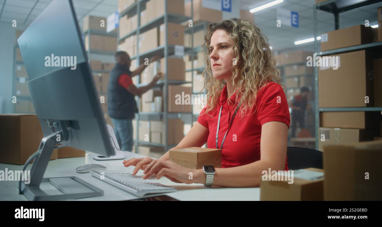 Female logistics specialist scans parcel using barcode scanner, checks data using computer ...