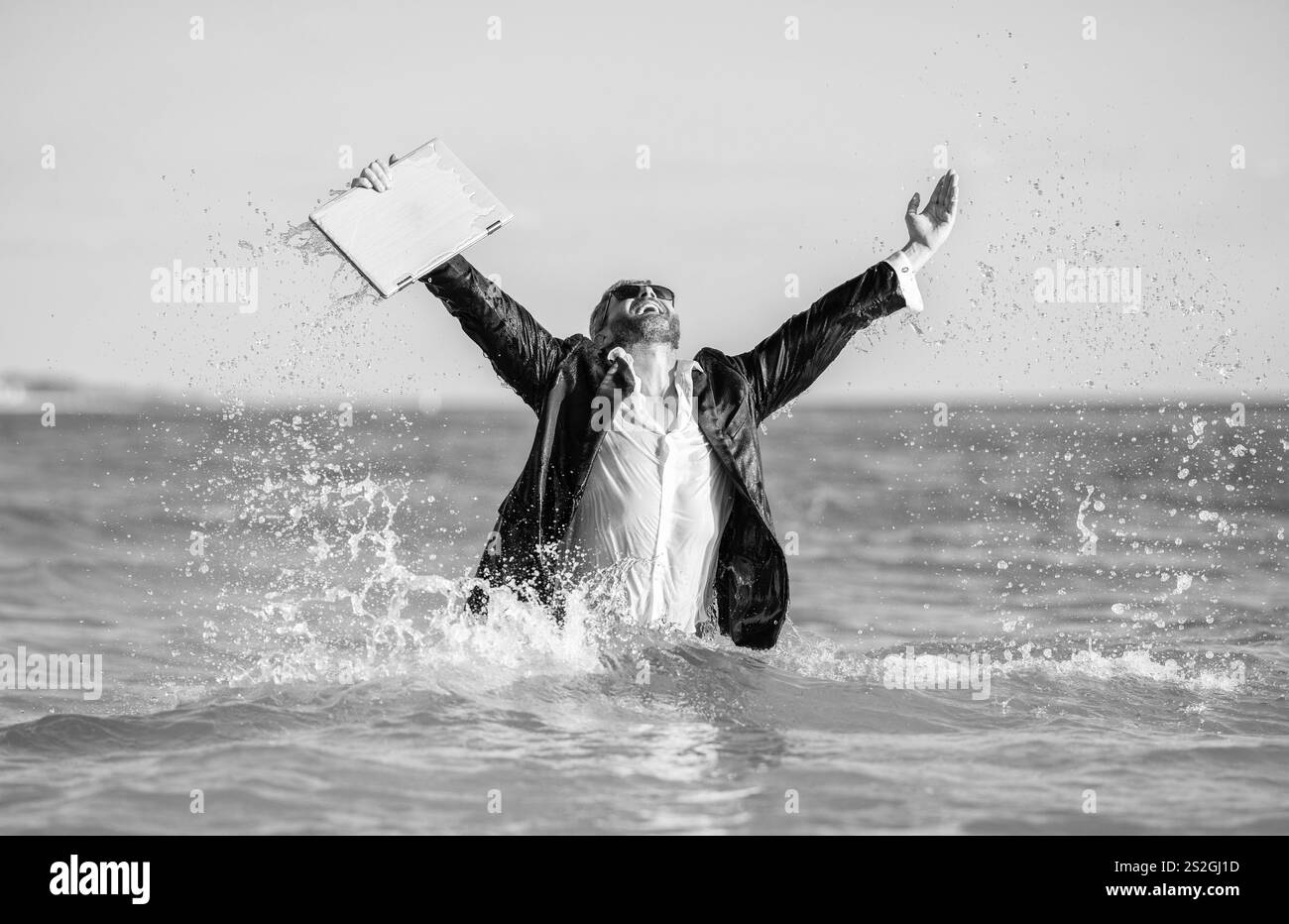 Excited businessman working laptop Black and White Stock Photos ...