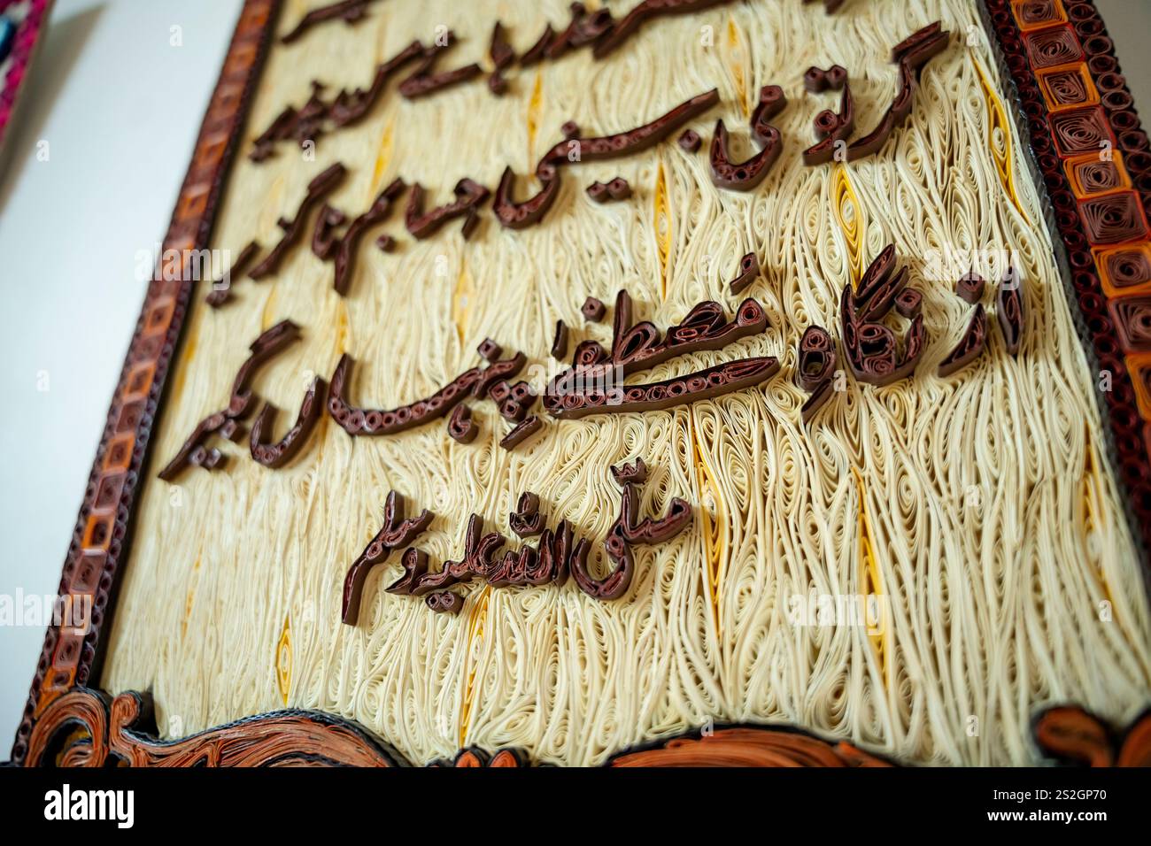 A calligraphy frame crafted with quilling paper is hanged on a wall at ...