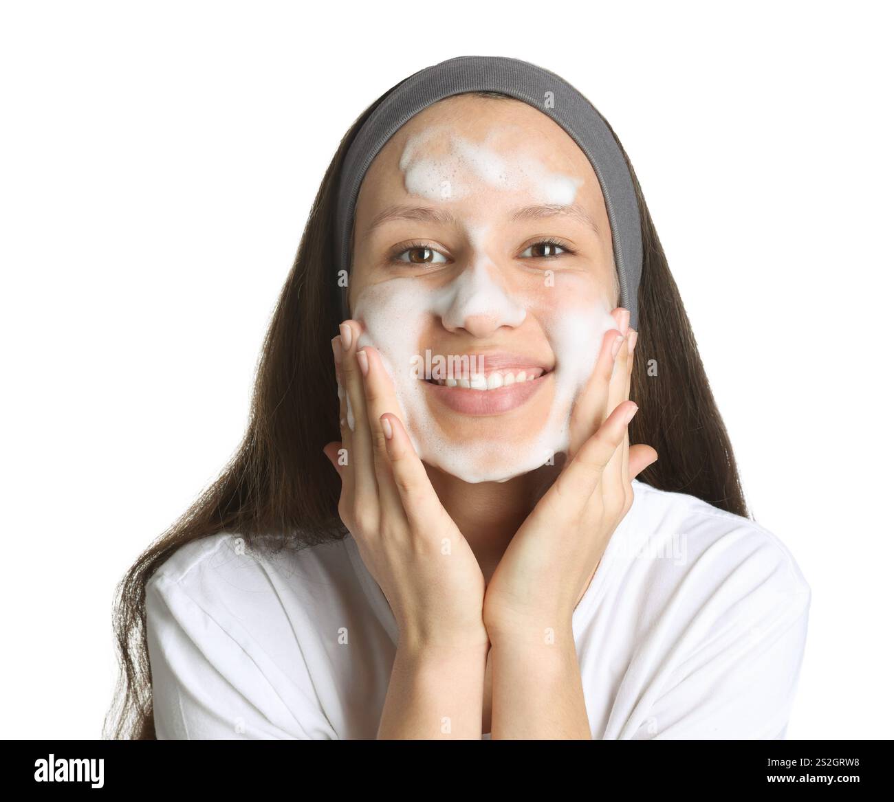 Teenage girl washing her face with cleanser on white background ...