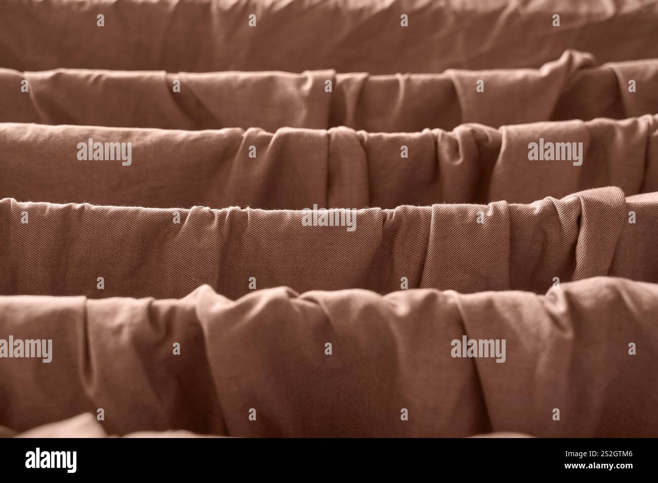 Close up textured brown fabric folds creating ripples and shadows in ...