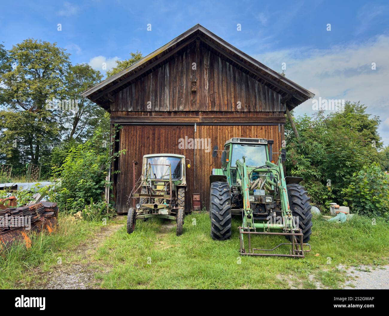 Ruderatshofen, Germany. 04th Aug, 2024. Old and new modern tractor side ...