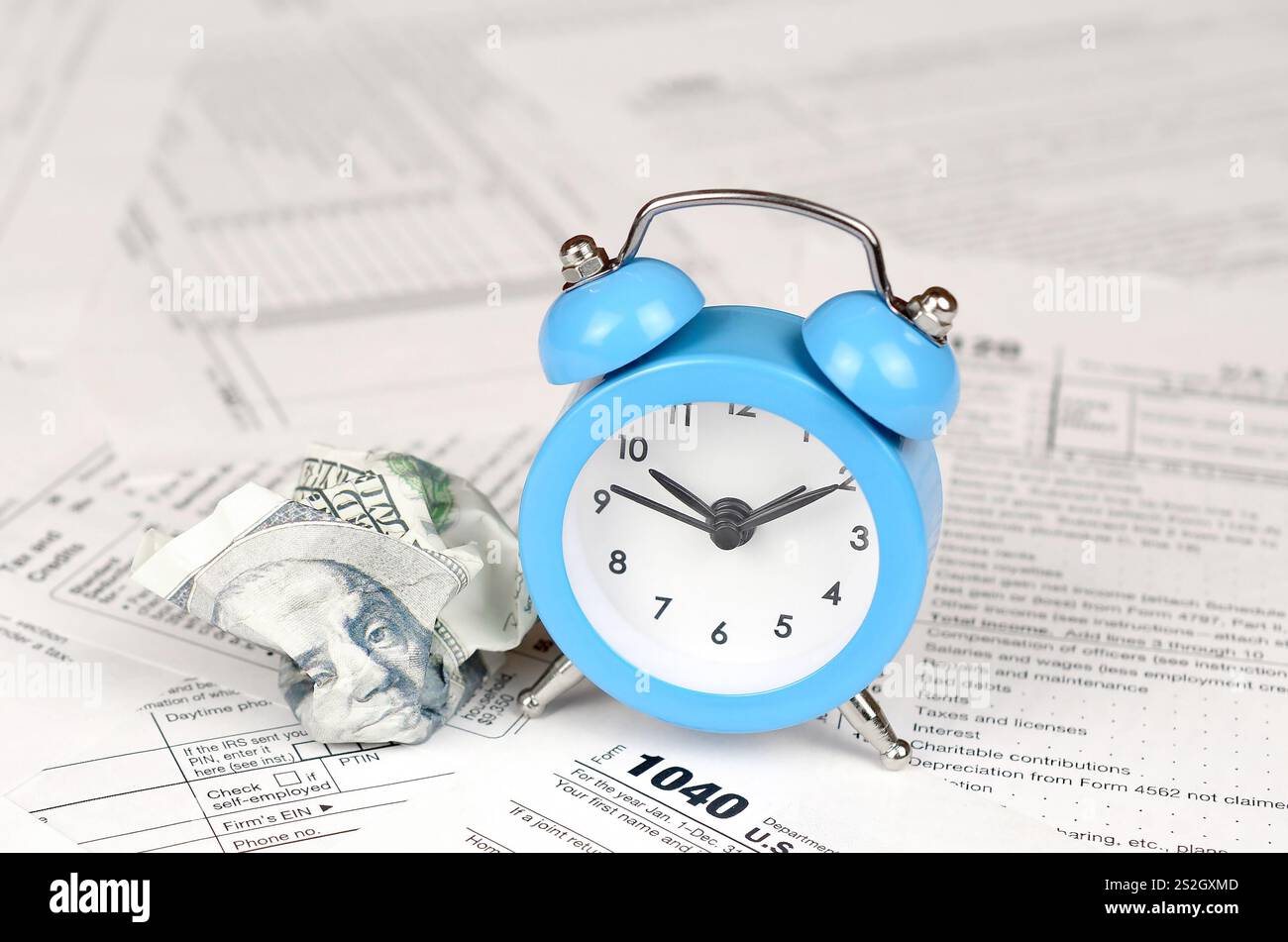 1040 Individual income tax return form with blue alarm clock and ...