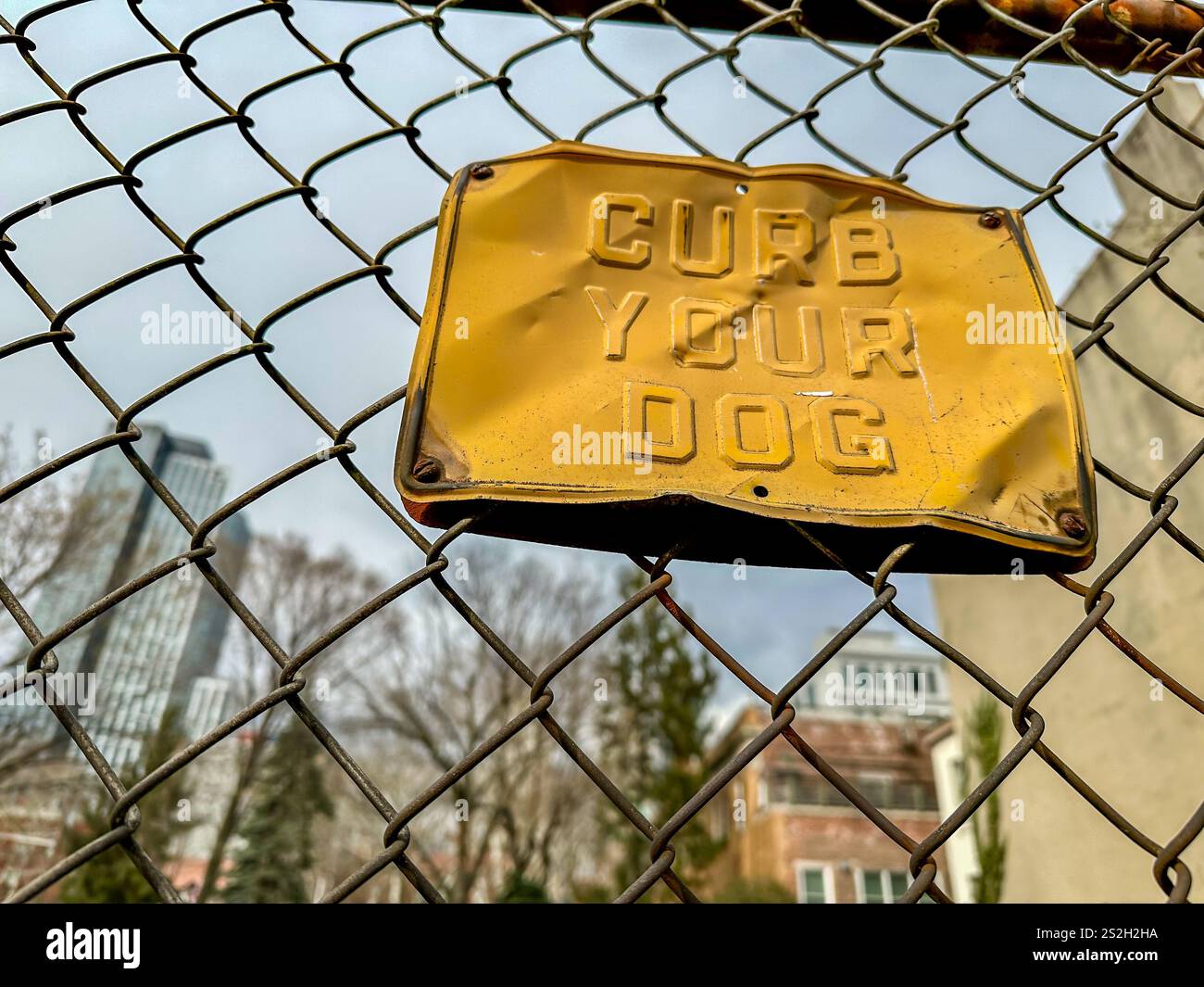 Curb your dog sign on chain link fence Stock Photo - Alamy