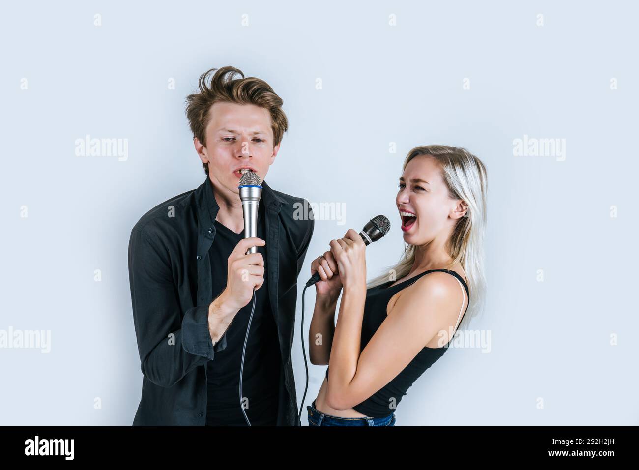 Happy portrait of Couple holding microphone and sing a song Stock Photo ...