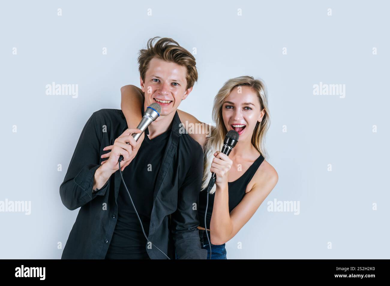 Happy portrait of Couple holding microphone and sing a song Stock Photo ...