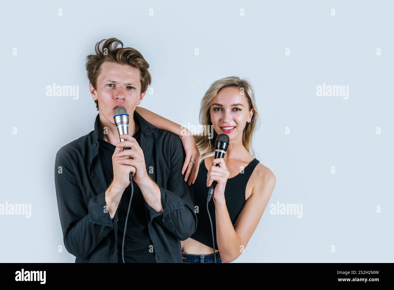 Happy portrait of Couple holding microphone and sing a song Stock Photo ...