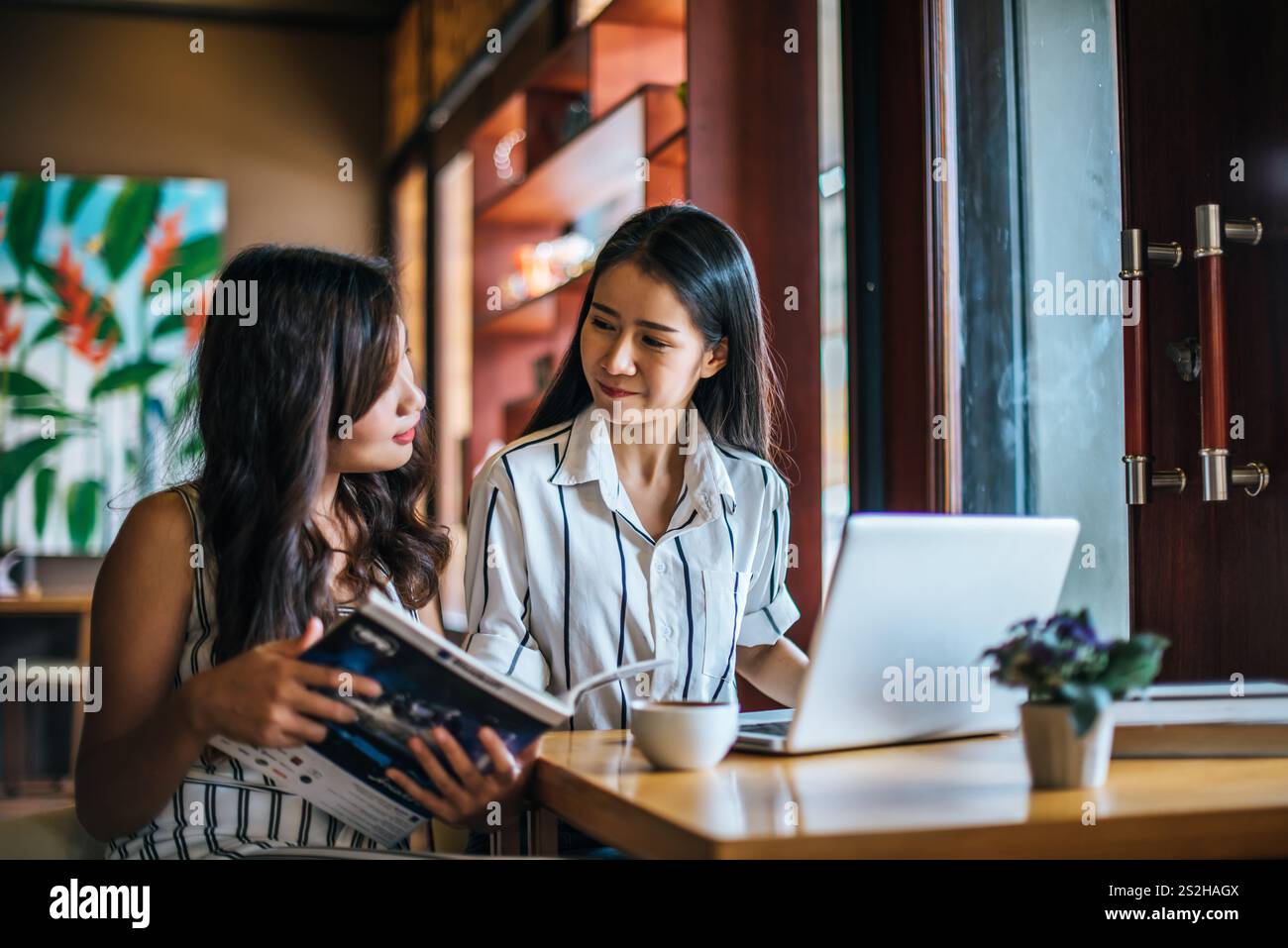 Two beautiful women talking everything together at coffee shop cafe ...