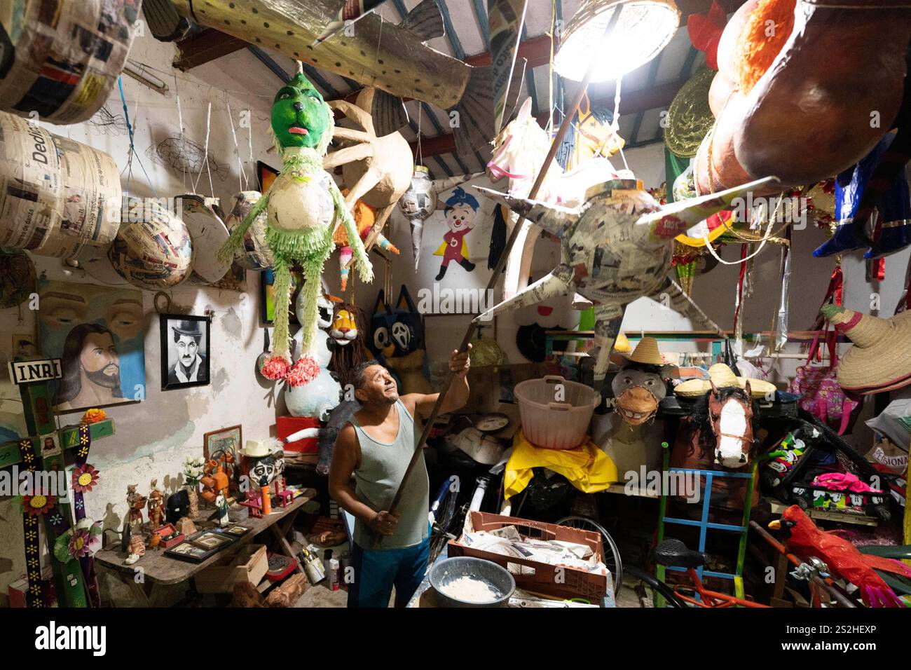 Baca, Mexico. 20th Nov, 2024. A man hanging up a pinata in his workshop ...