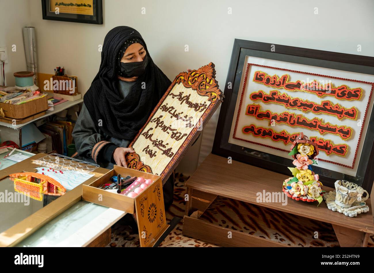 Sabreena Aaliya holds a calligraphy frame crafted with quilling paper ...