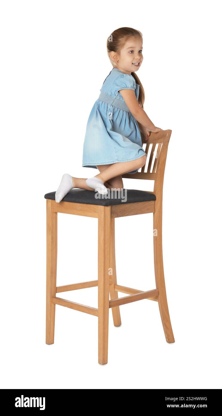 Little girl sitting on stool against white background Stock Photo - Alamy