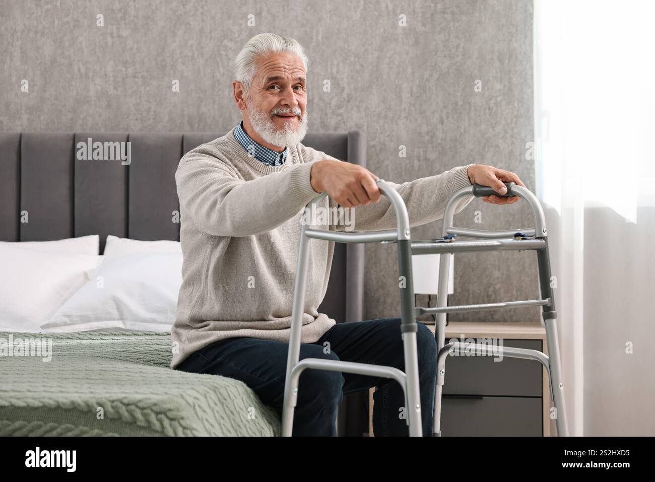 Senior man with walking frame on bed at home Stock Photo - Alamy