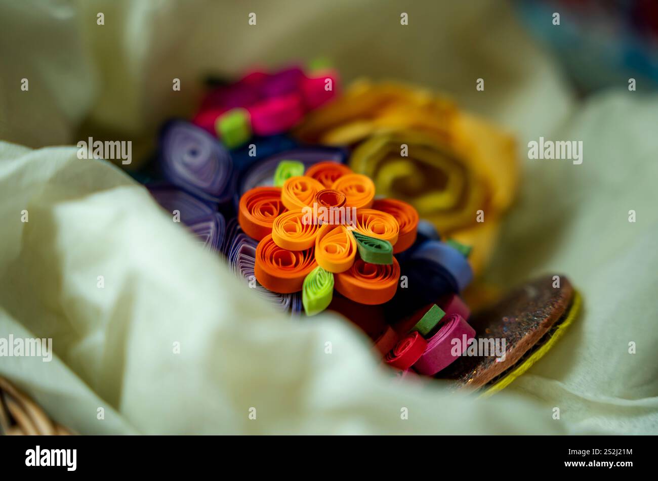 Flower designs crafted from quilling paper are seen at a home-based ...
