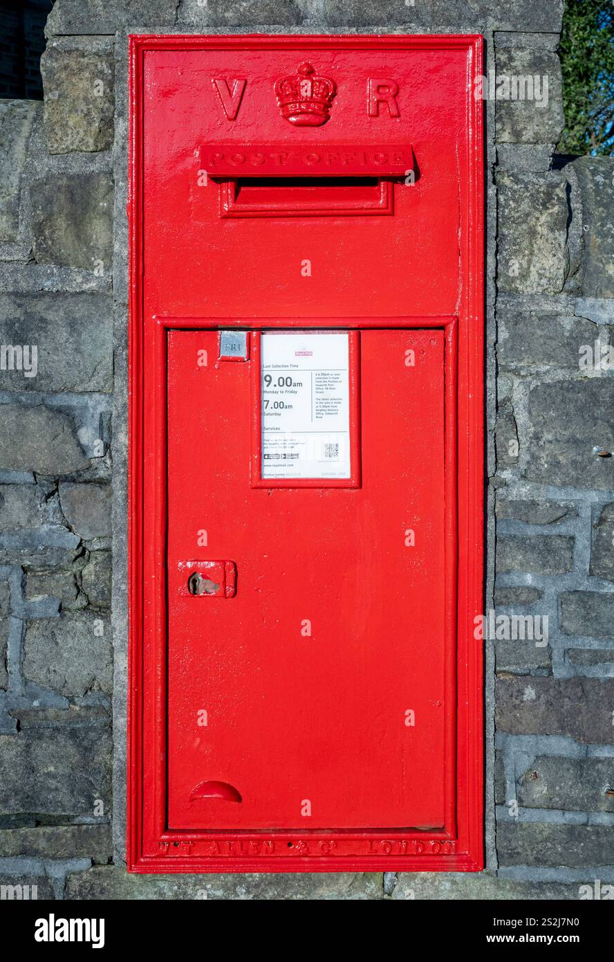 Red Victorian wall-mounted post box situated outside Haworth station ...