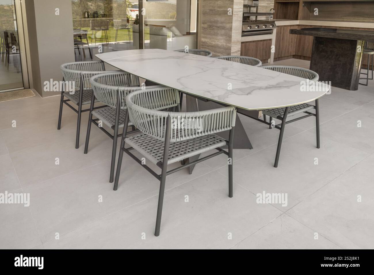 A dining room with metal and wicker chairs, complemented by a ceramic ...