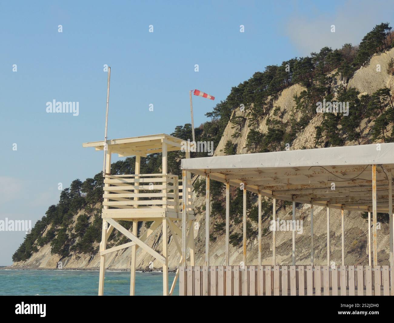 sea bay with light wooden observation platform against pine covered ...