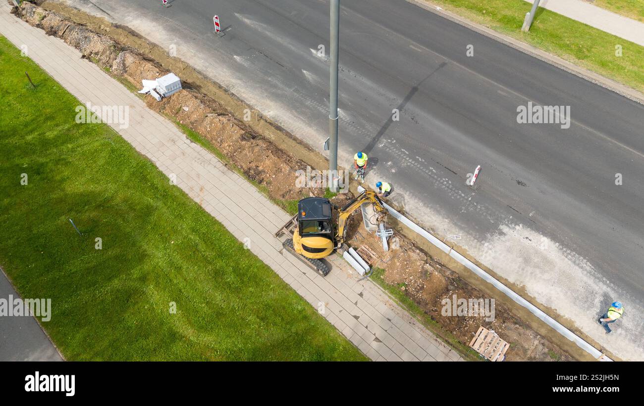 Aerial view of a construction site with workers constructing curb and ...