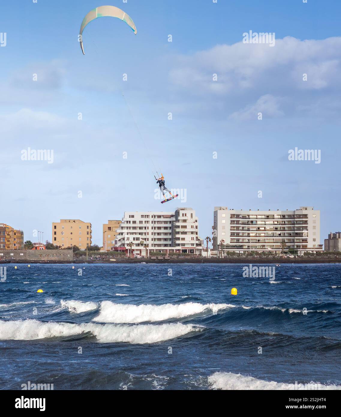 Vertical image of a kite surfer jumping high in the air at El Medano ...