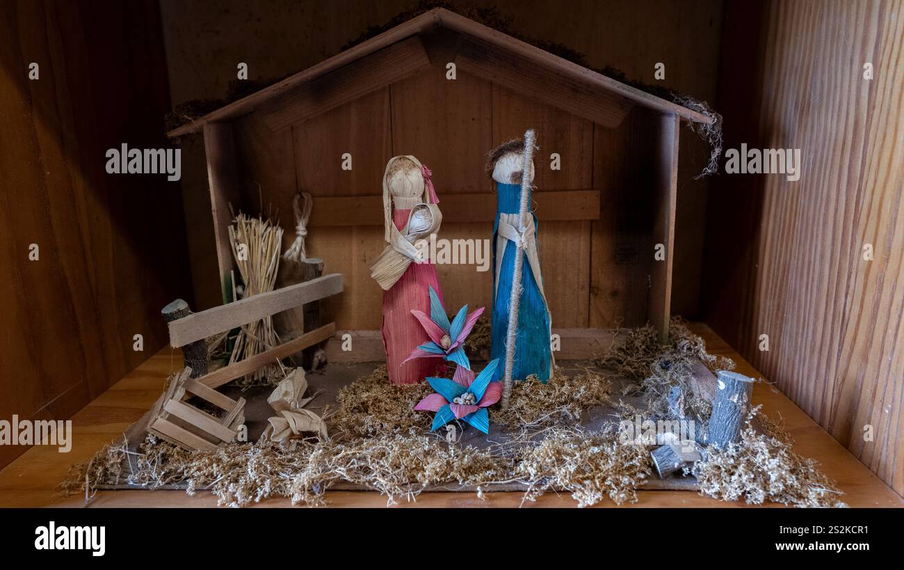 A handcrafted nativity scene inside a wooden stable, featuring ...