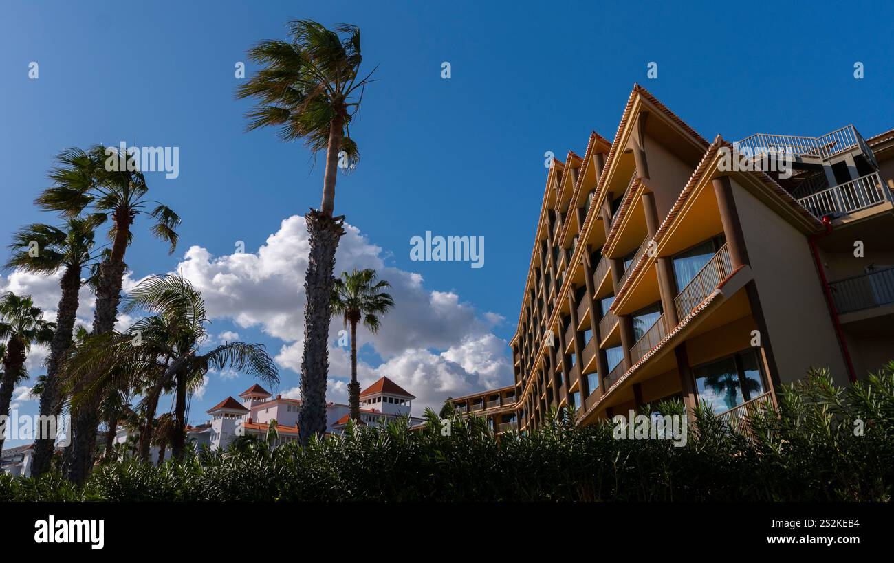 Modern resort building with triangular balconies surrounded by tall ...