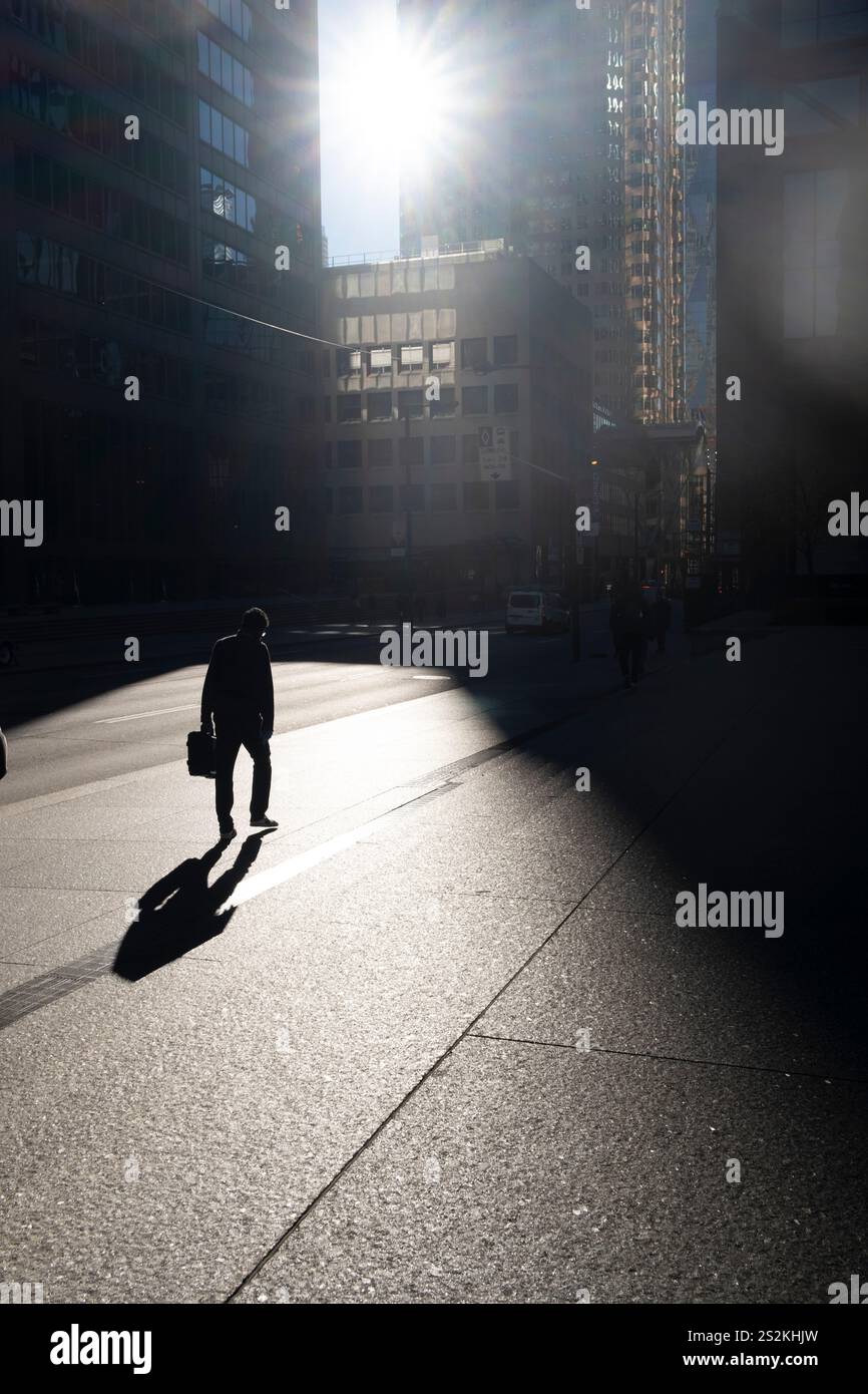 Urban street photography with people in shadows in tall skyscrapers ...