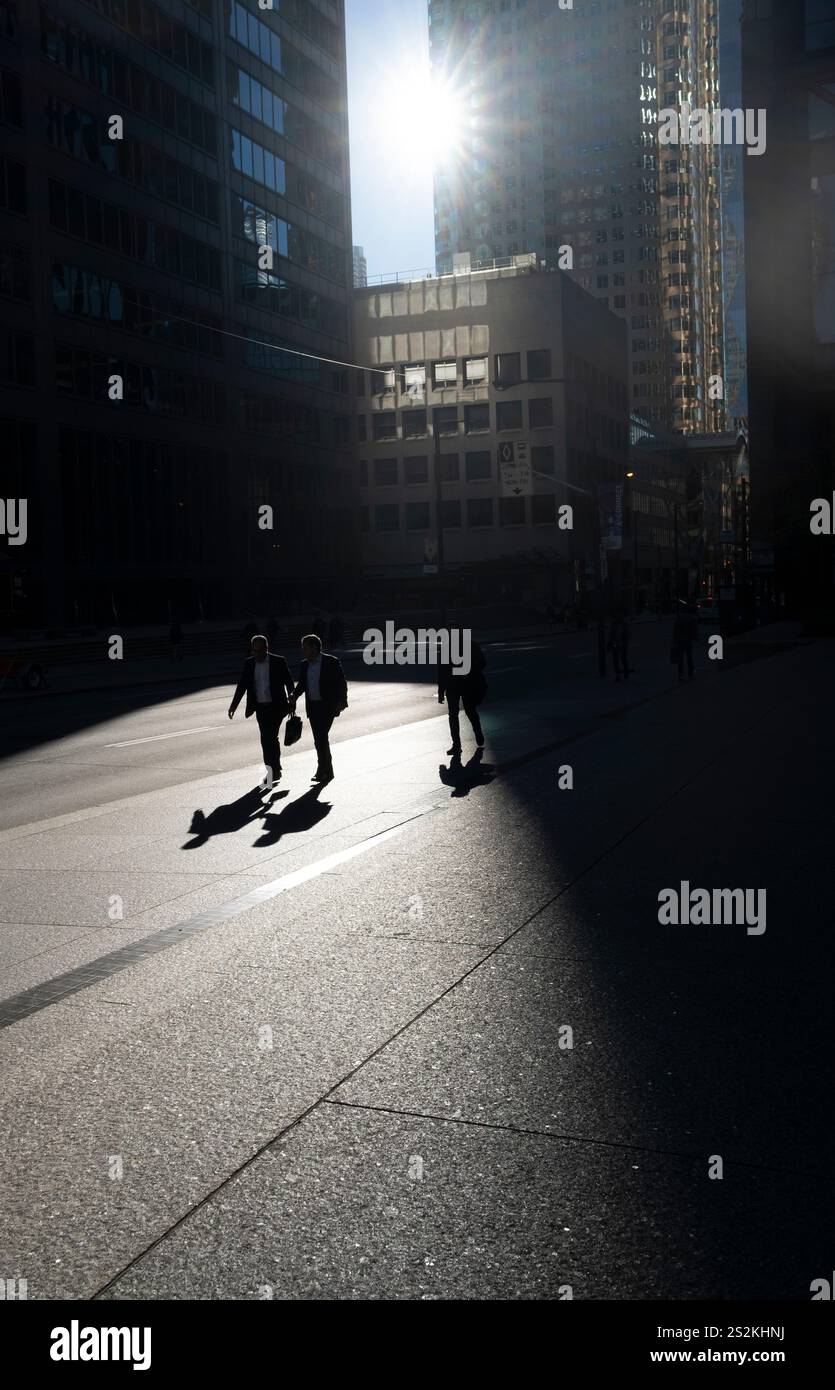 Urban street photography with people in shadows in tall skyscrapers ...