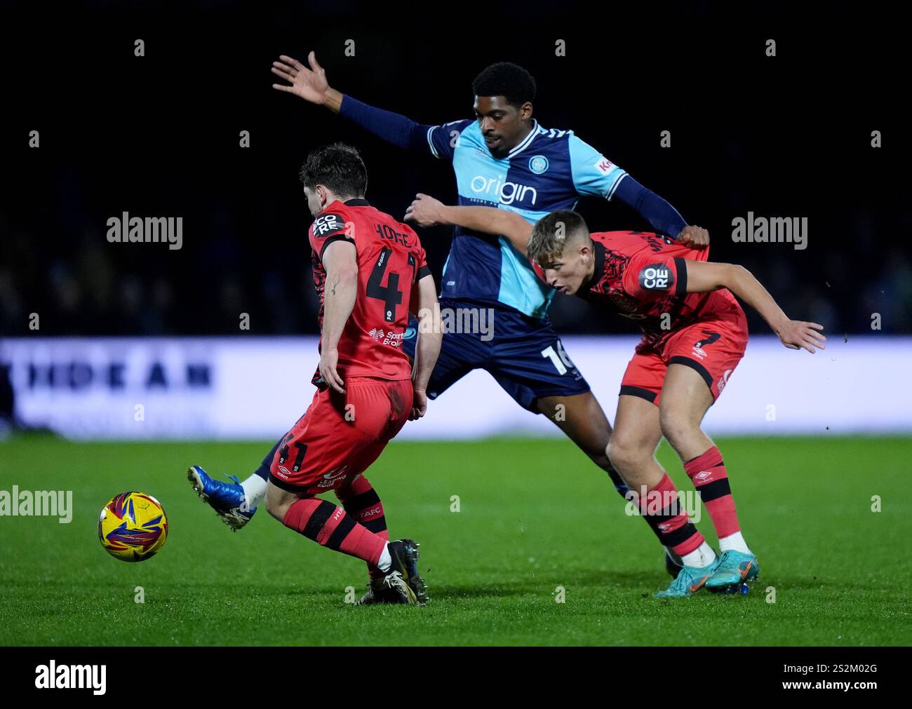 Wycombe Wanderers's Treeq Bakinson (centre) and Huddersfield Town's Joe ...