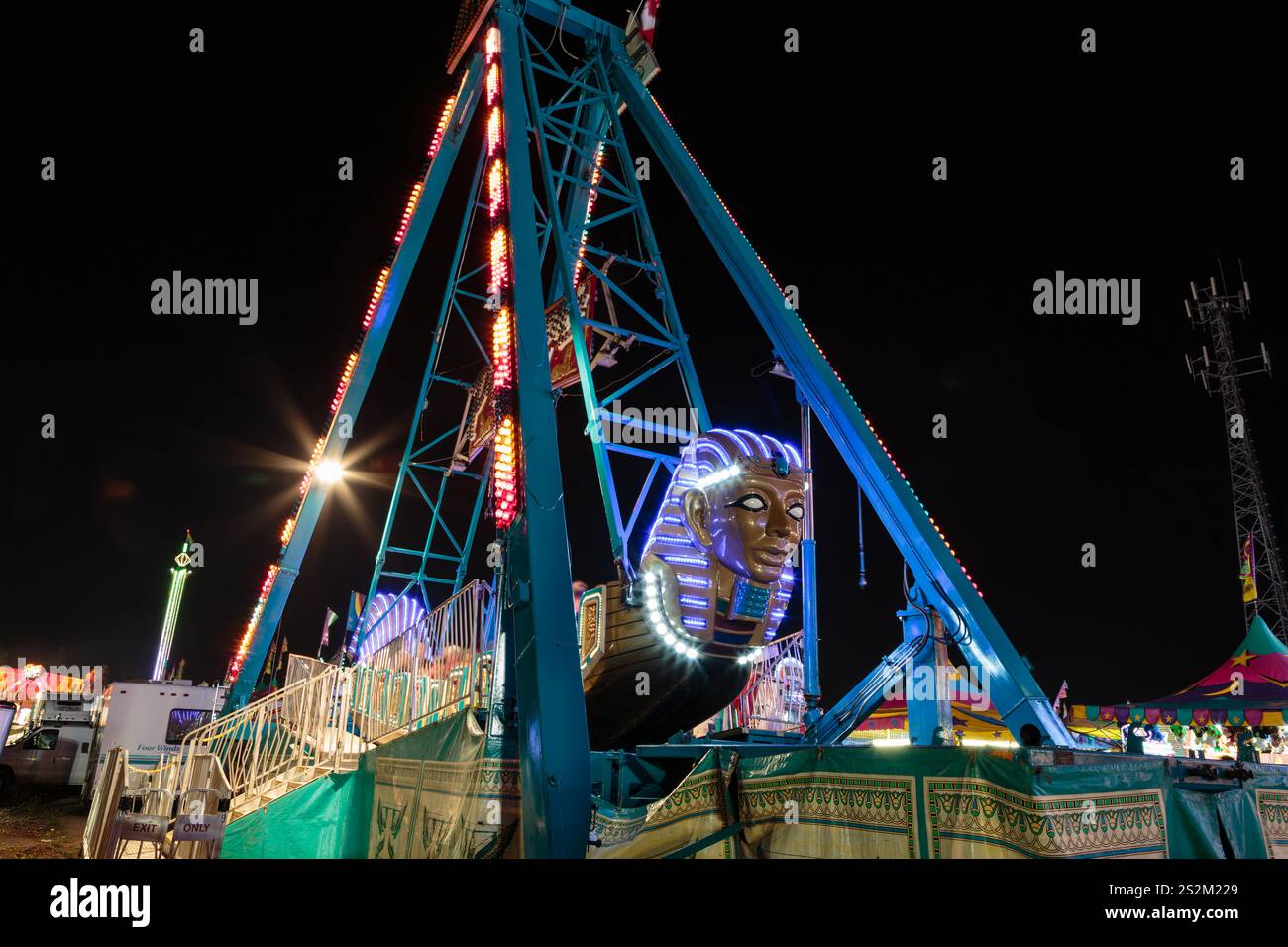 A large blue roller coaster with a statue of a pharaoh on it. The ...