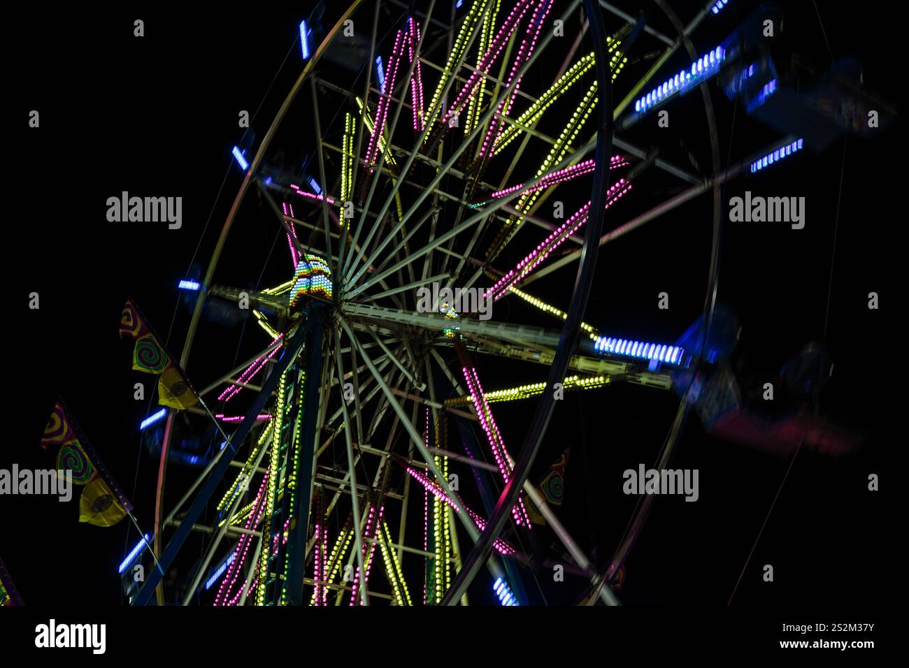 A colorful merry go round with lights on it. The lights are bright and ...