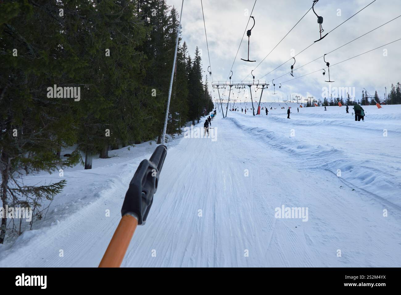 The view of riding a t-bar lift in going upwards a skiing slope in a ...