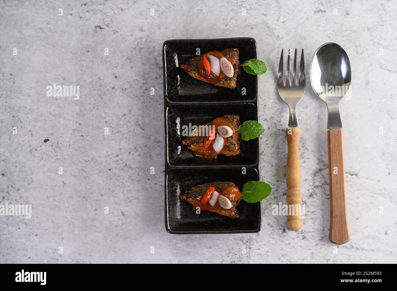 Top view with Appetizers with the spicy sardine in ceramic tray, spoon ...