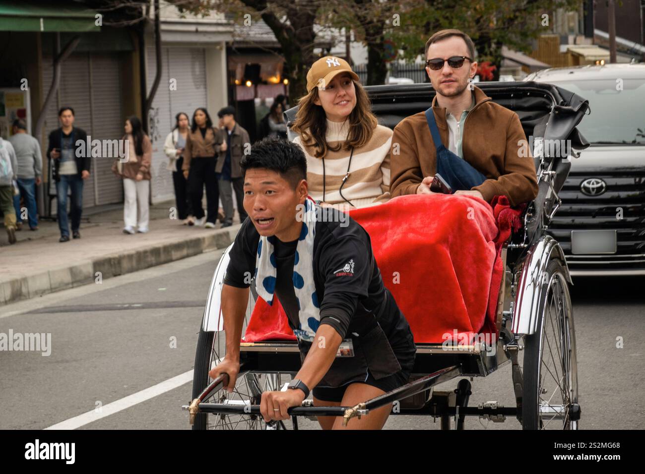 couple riding in a rickshaw on the streets of Nara Japan Stock Photo ...