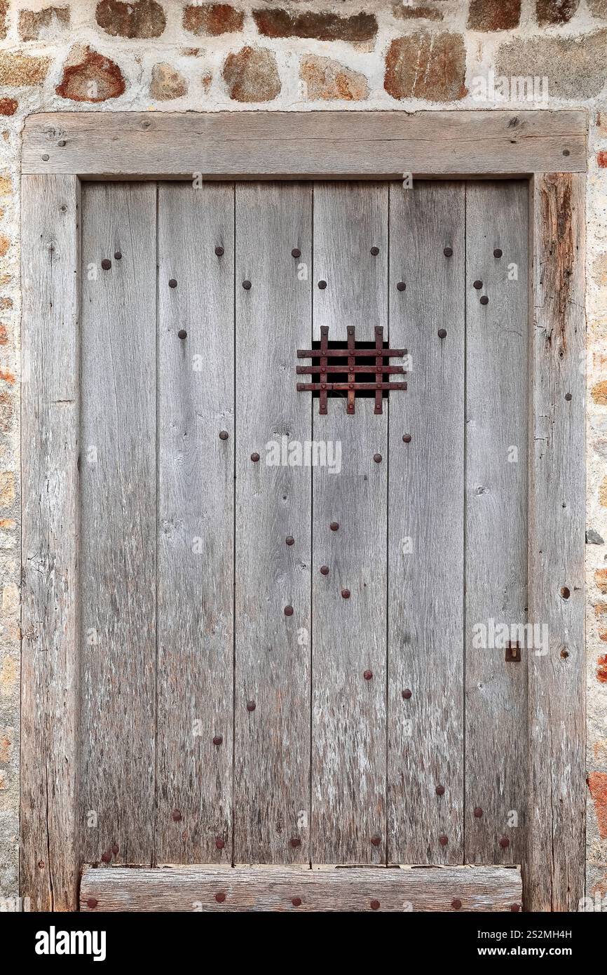 172 Mont-Saint-Michel: Old unpainted, studded wood door with grating ...