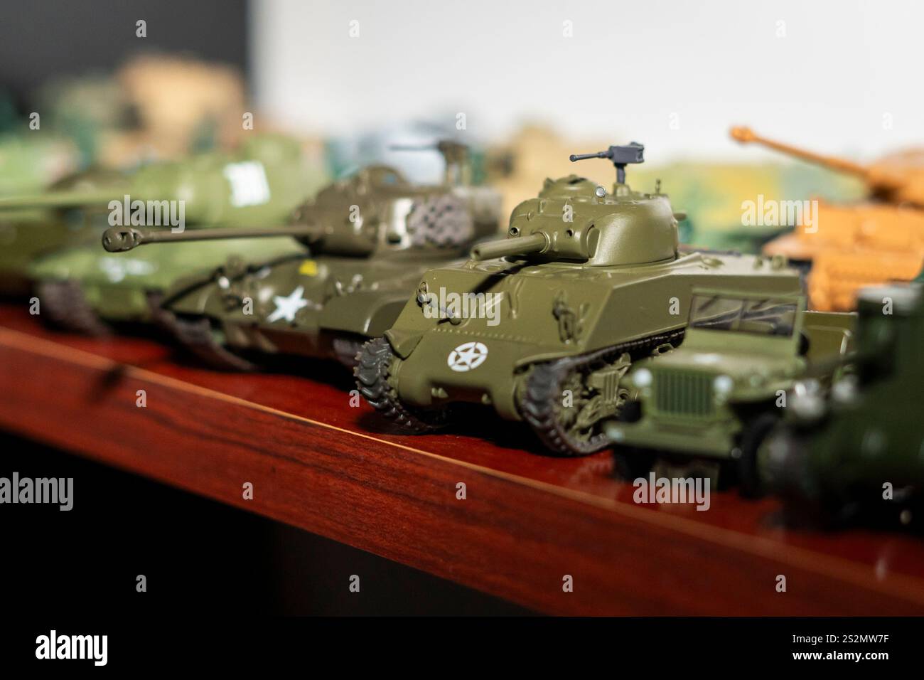 Sherman, Pershing and other WWII tank models on a brown wooden shelf ...
