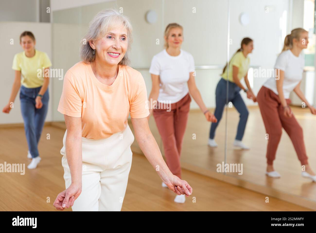 Elderly woman dancing jazz during group training Stock Photo - Alamy